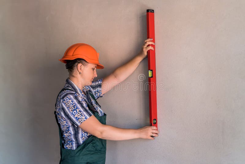 Woman Builder Measuring Wall with Water Level Stock Photo - Image of ...