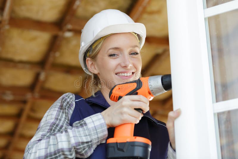 Woman builder using drill stock image. Image of homeimprovement - 268033995