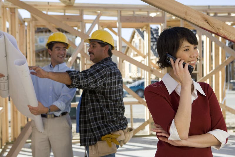 Woman on Call with Contractors in Background Stock Image - Image of ...