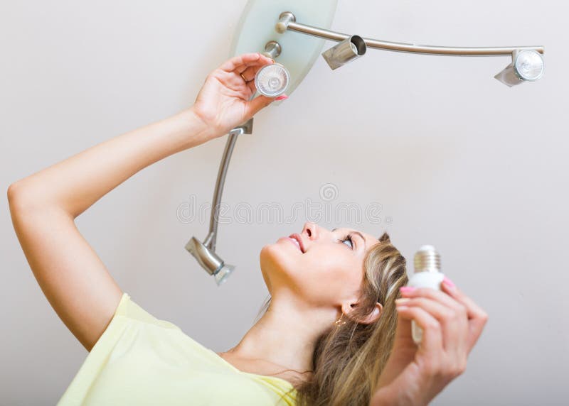 Woman changing light bulbs stock photo. Image of pretty - 74452540