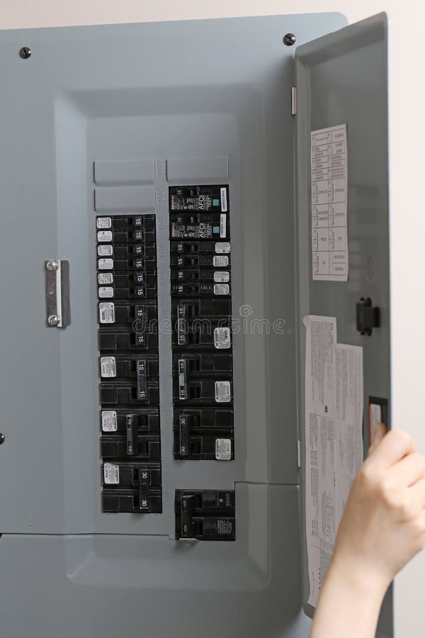 Woman checking automatic fuses at electrical control panel, Woman ...