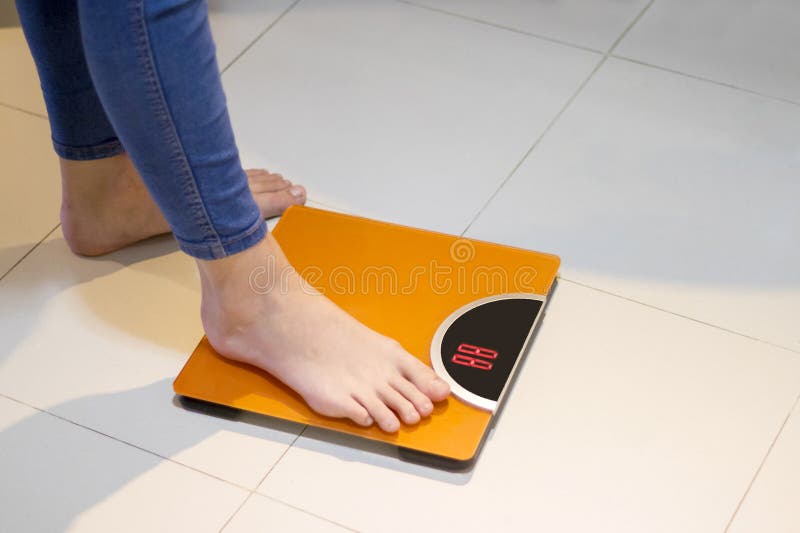 Woman Checking Her Weight by Stepping Onto a Bathroom Scale Stock Image ...