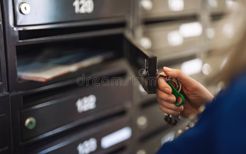 Woman checking mailbox stock photo. Image of letterbox - 299673224