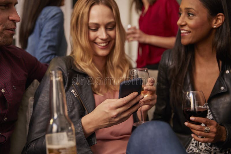 Woman Checking Mobile Phone at Party with Friends Stock Photo - Image ...
