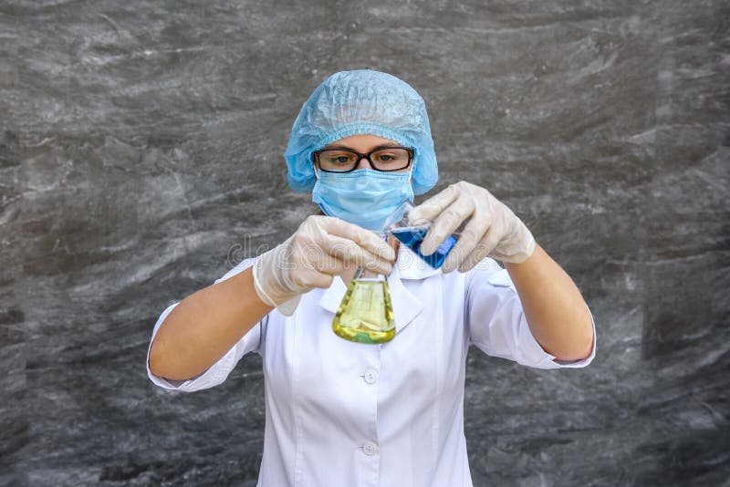 Woman Chemist in Protective Uniform Making Experiment with Blue and ...