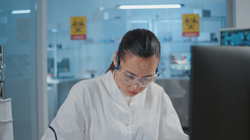 Woman Chemist Taking Notes and Using Computer for Experiment Stock ...