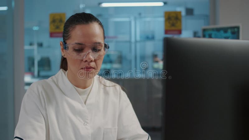Woman Chemist Taking Notes and Using Computer for Experiment Stock ...