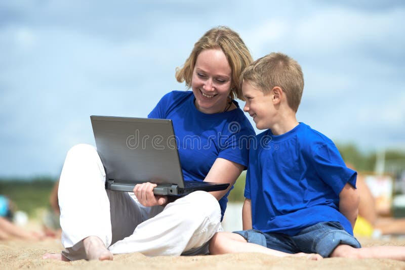 Woman and Child with Computer at Seaside Stock Photo - Image of ...