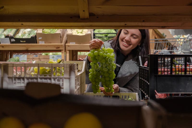 A Woman Chooses Grapes in a Store Stock Photo - Image of fresh, people ...