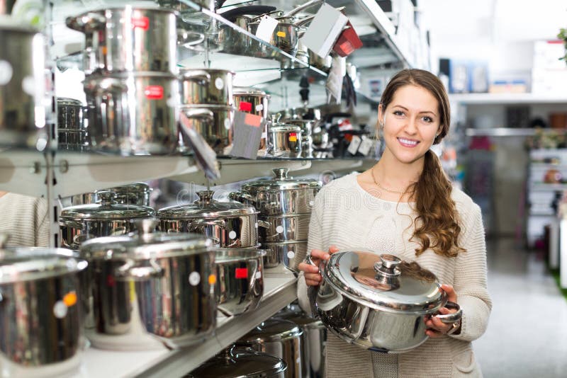 Woman chooses pan in shop stock photo. Image of female - 81928004
