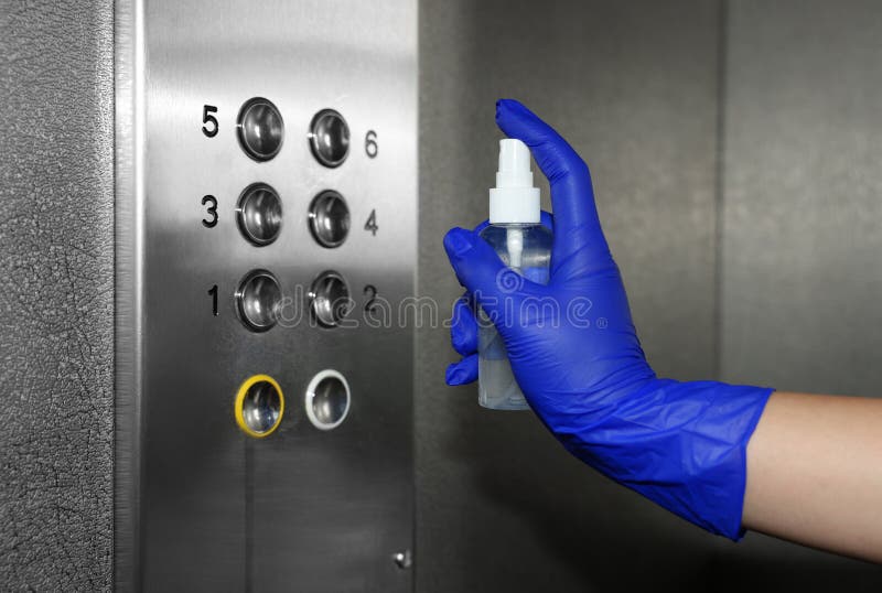 Woman Cleaning Buttons Panel in Elevator with Detergent Spray, Closeup ...