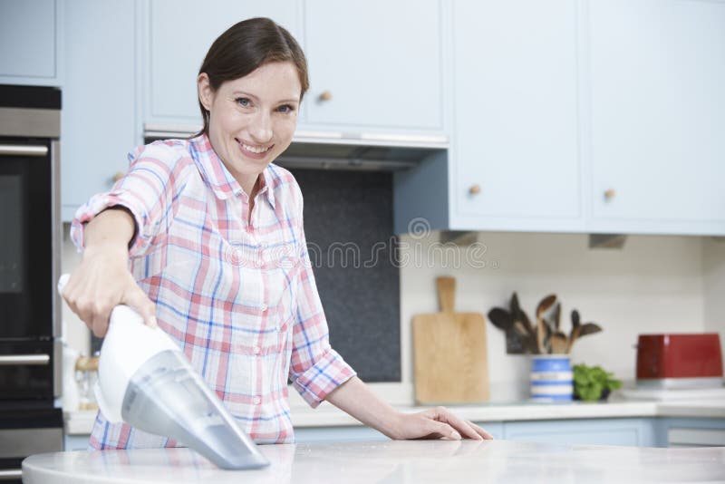 Woman Cleaning Kitchen Using Hand Held Vacuum Cleaner Stock Photo ...