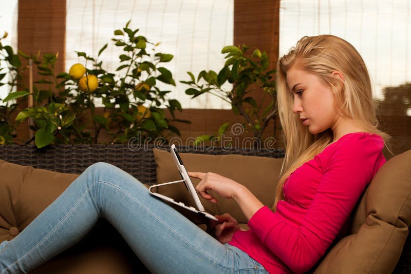 Woman Comfortable Sitting on Sofa and Using Tablet Computer. Stock ...
