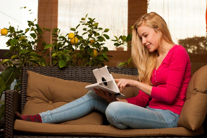 Woman Comfortable Sitting on Sofa and Using Tablet Computer. Stock ...