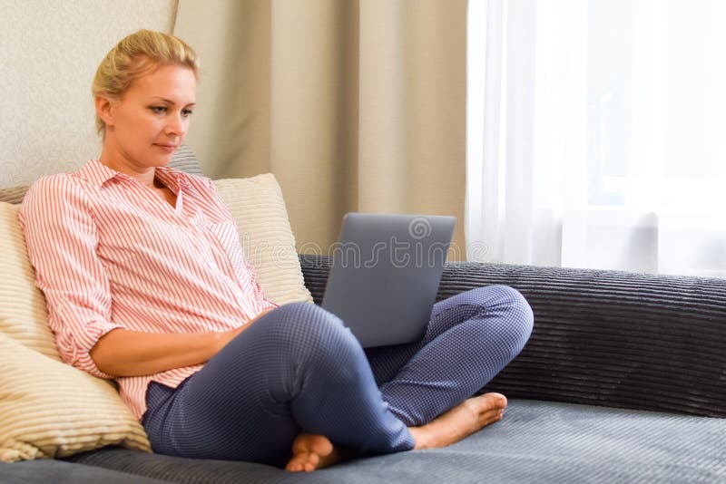 Woman with a Computer on the Couch Works. Remote Work Freelancer Stock ...