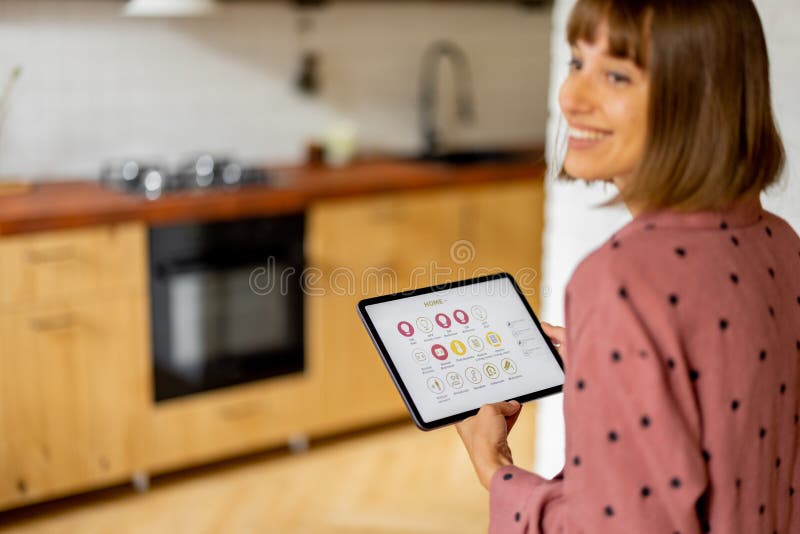 Woman Controls Home Devices with a Digital Tablet at Home Stock Image ...