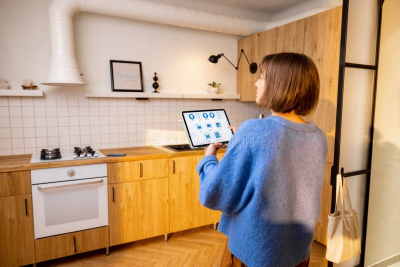 Woman Controls Kitchen Appliances with a Digital Tablet Stock Image ...