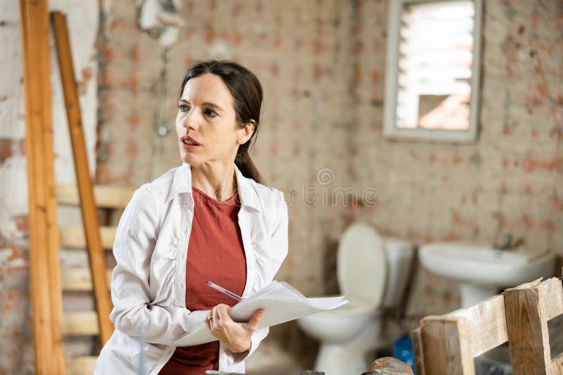 Woman Controls the Progress of Repair Work and Keeps Notes on Piece of ...