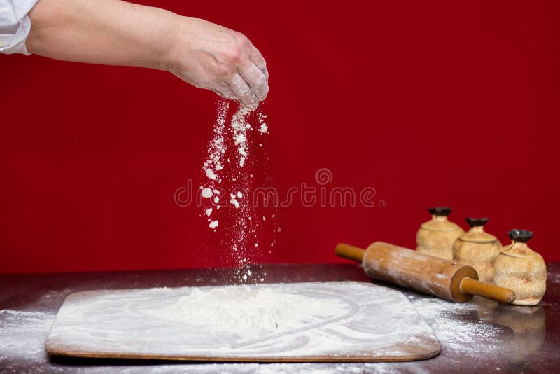 A Woman Cook Sprinkling Flour Over a Cutting Board Stock Image - Image ...