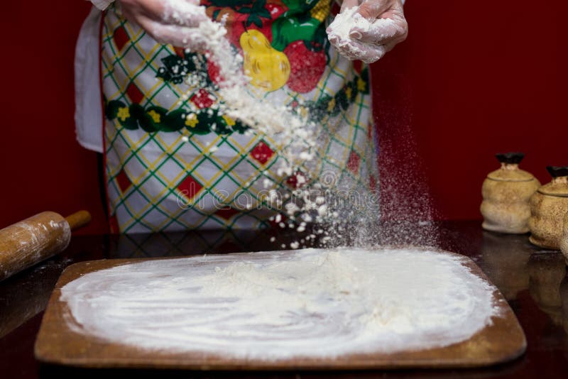 A Woman Cook Sprinkling Flour Over a Cutting Board Stock Photo - Image ...