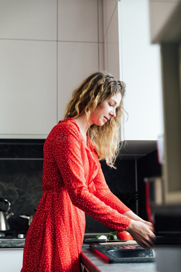 Beautiful Woman Cooks in the Kitchen Peeling Vegetables Stock Photo ...