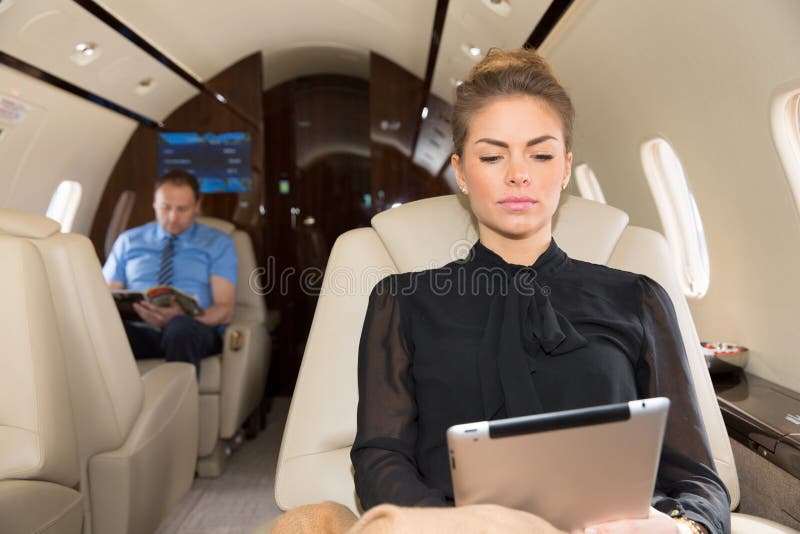 Woman in Corporate Jet Looging at Tablet Computer Stock Image - Image ...