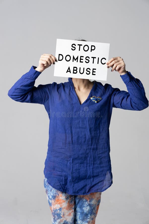 Woman Covering Her Face with a White Poster with the Words Stop ... Woman Covering Her Face with a White Poster with the Words Stop ...