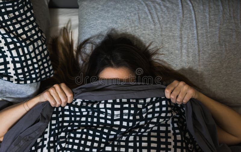 Woman Covers Her Face with the Sheets of Her Bed. Stock Photo - Image ...