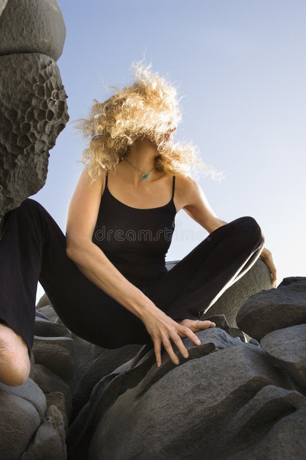 Woman crouching on rocks. stock photo. Image of recreation - 3419082