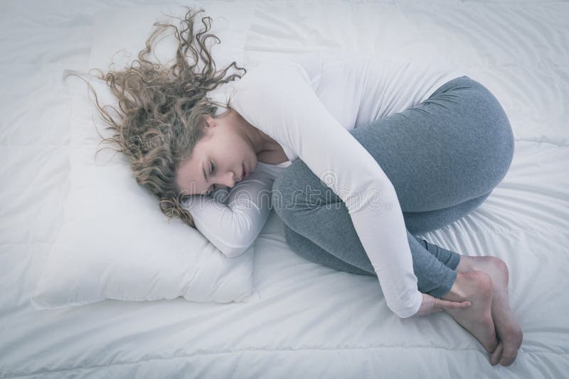 Woman curled up in bed stock photo. Image of teenager - 54967516