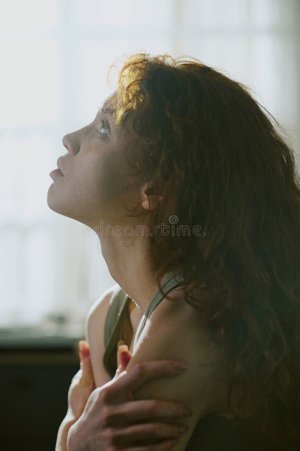 Contemplating Woman with Curly Hair Backlit by Sunlight Stock Image ...