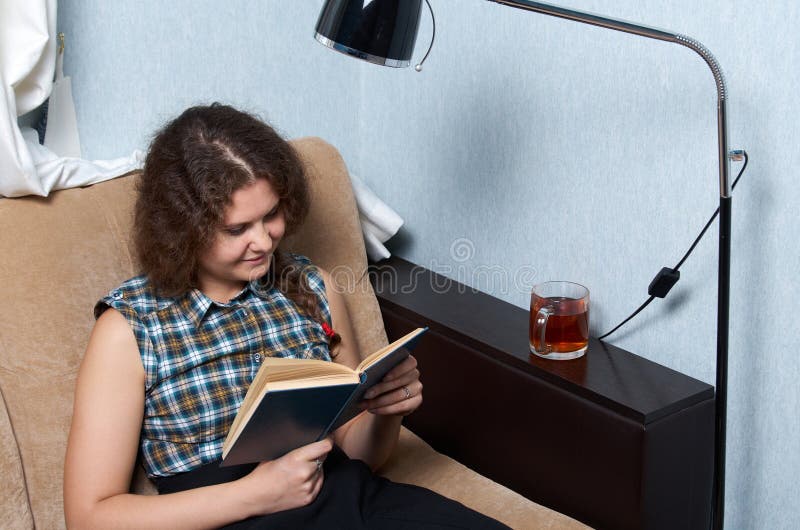 Woman with Curly Hair Reading a Book on Sofa Stock Photo - Image of ...
