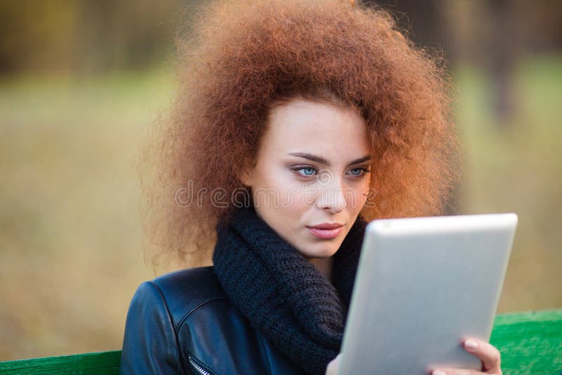 Woman with Curly Hair Using Tablet Computer Outdoors Stock Image ...