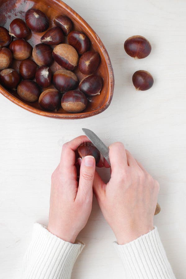 Woman cut the raw chestnut stock photo. Image of plate - 101240066