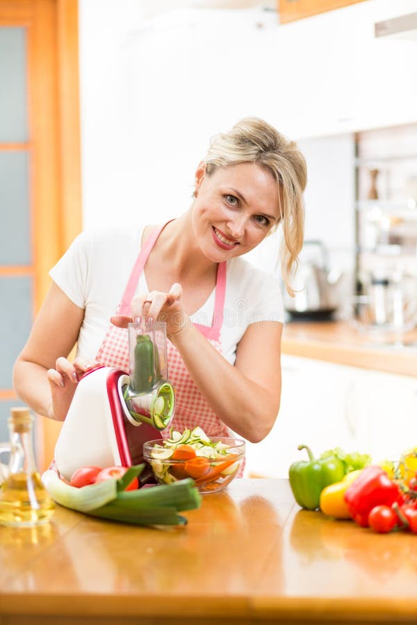 Woman Cutting Vegetables with Device at the Kitchen Table Stock Photo ...
