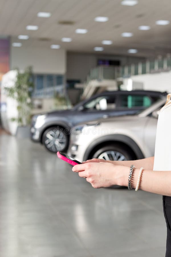 Woman Dealer Using Mobile Smart Phone at Dealer Showroom. Modern ...