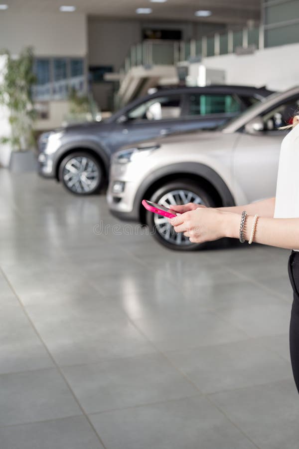 Woman Dealer Using Mobile Smart Phone at Dealer Showroom. Modern ...