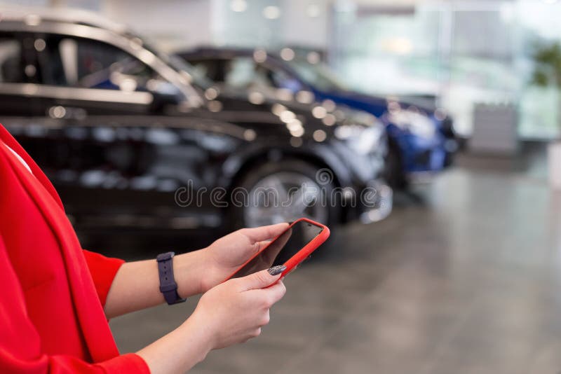 Woman Dealer Using Mobile Smart Phone at Dealer Showroom. Modern ...