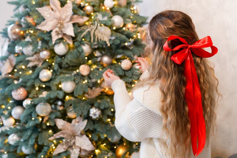 Woman Decorates a Christmas Tree for the Holiday. Light Background ...