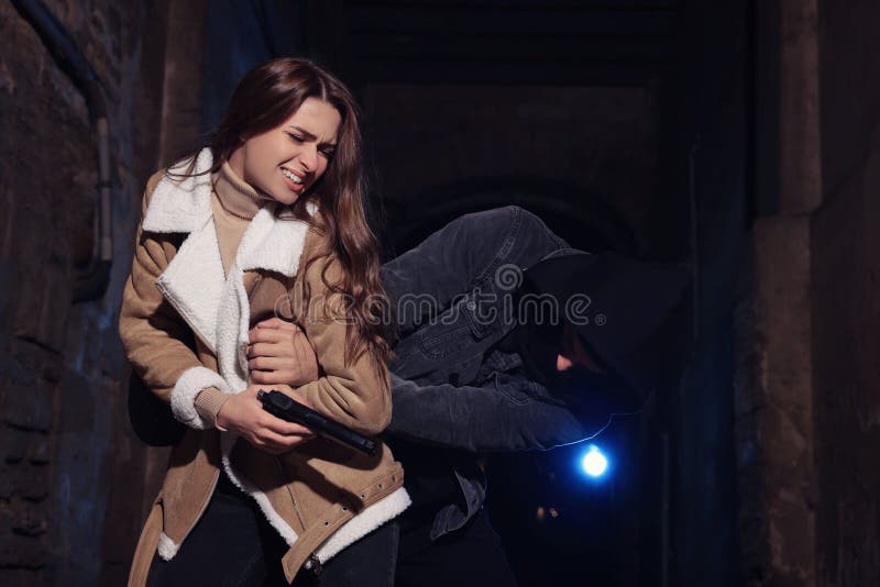 Woman Defending Herself from Attacker with Gun in Alley at Night Stock ...
