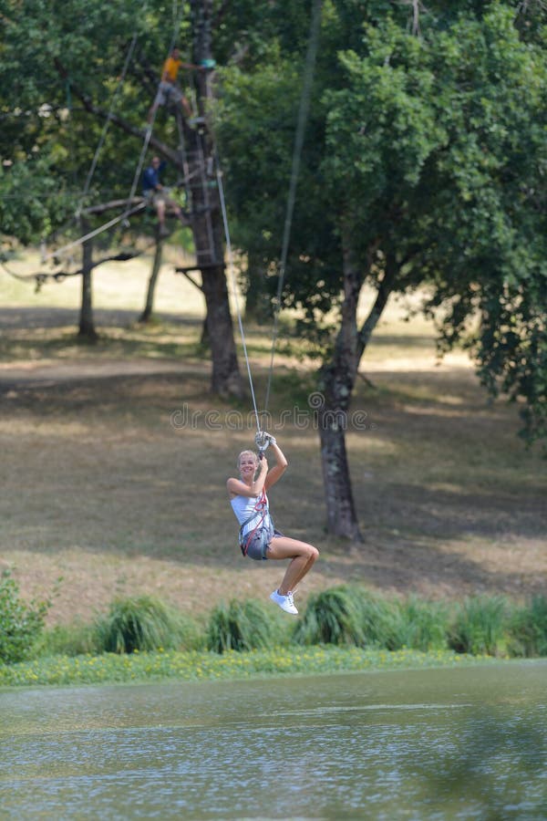 Woman Descending Zip Wire Over Lake Stock Image - Image of risky, wire ...