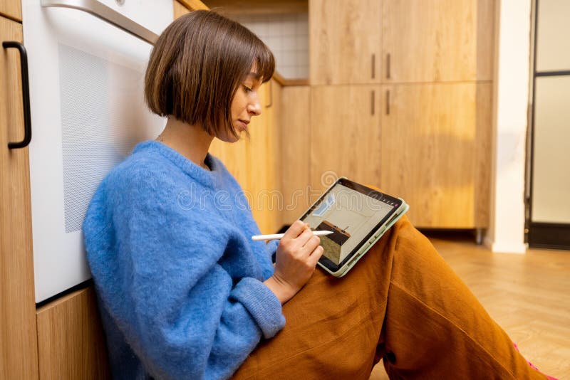 Woman Designing Kitchen Interior on a Digital Tablet at Home Stock ...