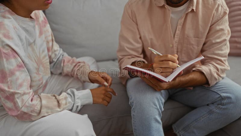Woman Discussing with Man Writing Notes in an Interior Living Room ...