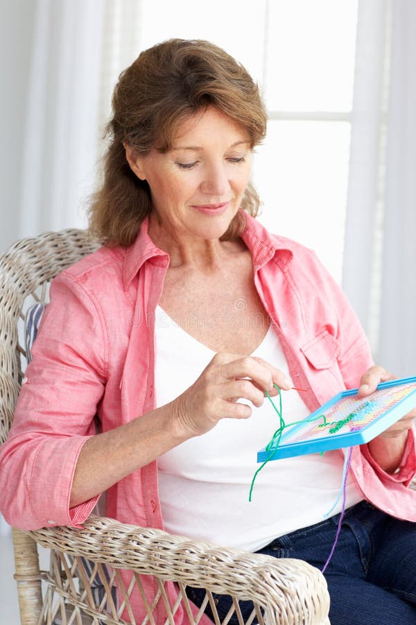 Woman doing cross stitch stock image. Image of senior - 21047797
