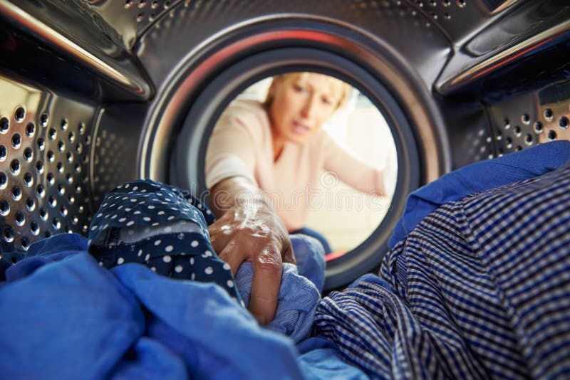 Woman Doing Laundry Reaching Inside Washing Machine Stock Photo - Image ...