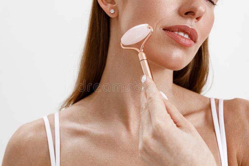 Woman Doing Massage With Stone Facial Roller On White Background