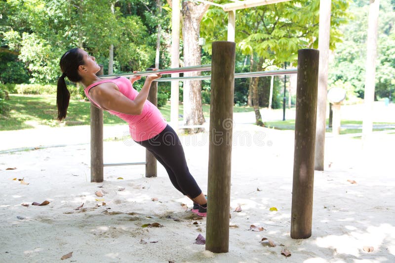 Woman Pull-ups Herself Up On Bar On Sports Ground In Park. Stock Image ...