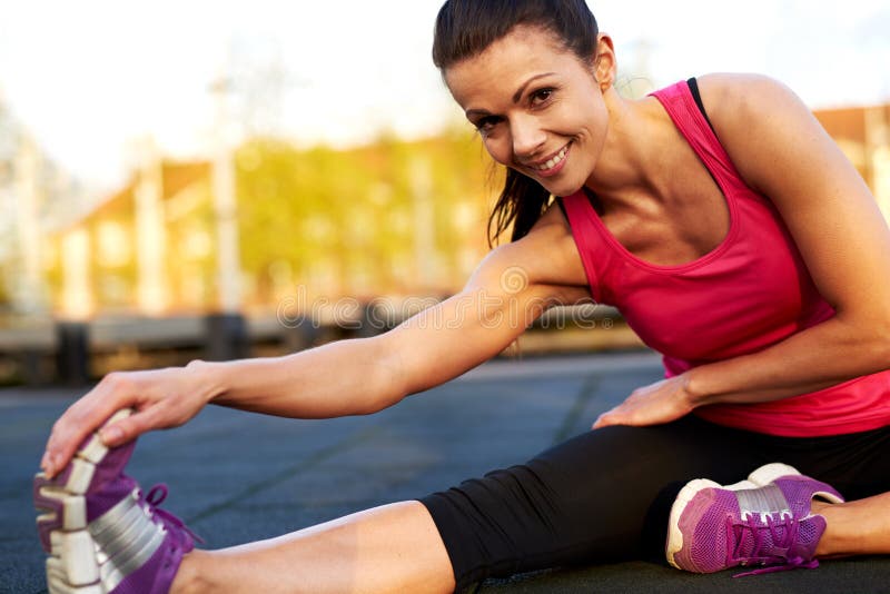 Woman Doing a Seated Hamstring Stretch Smiling at Camera. Stock Image ...