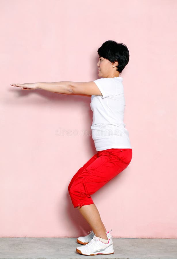 Woman Doing Squats Over a Pink Wall Stock Image - Image of squats, body ...