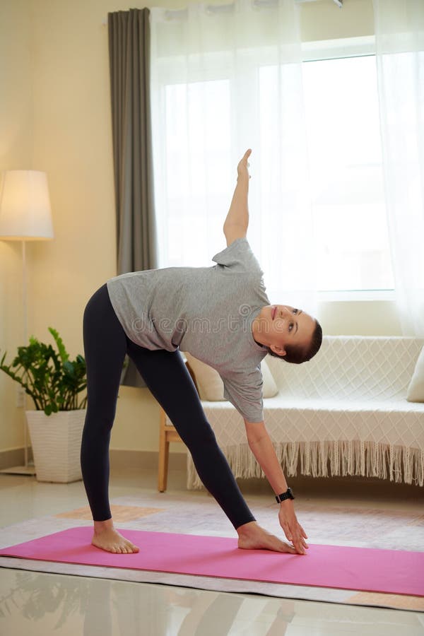 Woman Practicing Triangle Pose Stock Photo - Image of yoga, strength ...